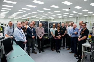The ATOM design team next to the product's automated assembly cell